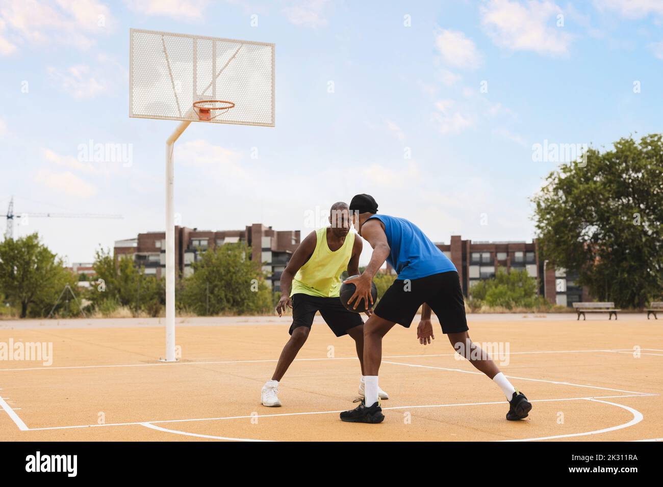 Father playing basketball with son defending at court Stock Photo - Alamy