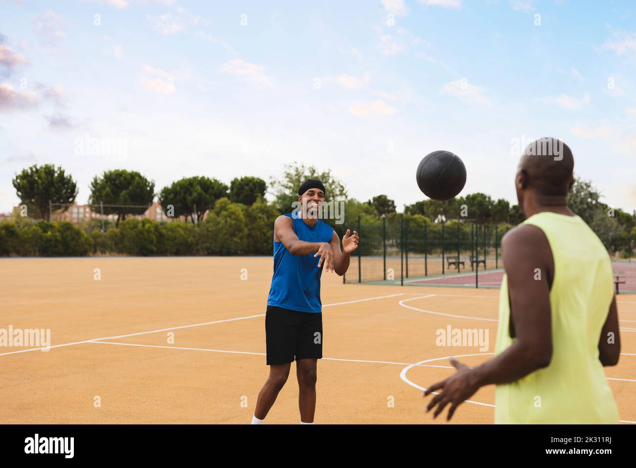 Son throwing ball to father playing at basketball court Stock Photo - Alamy