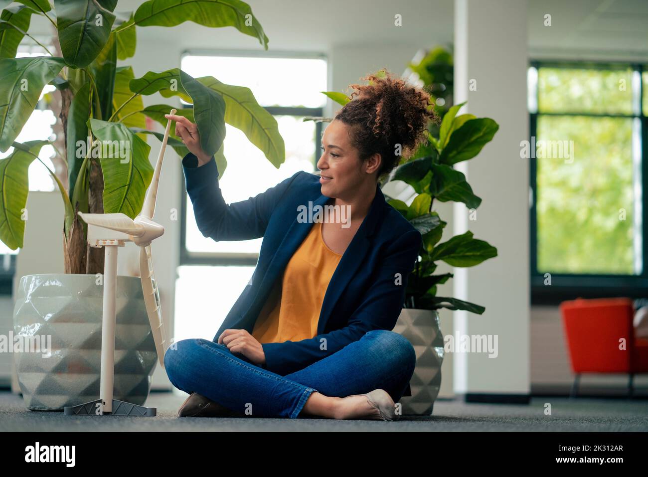 Businesswoman examining wind turbine model at workplace Stock Photo - Alamy