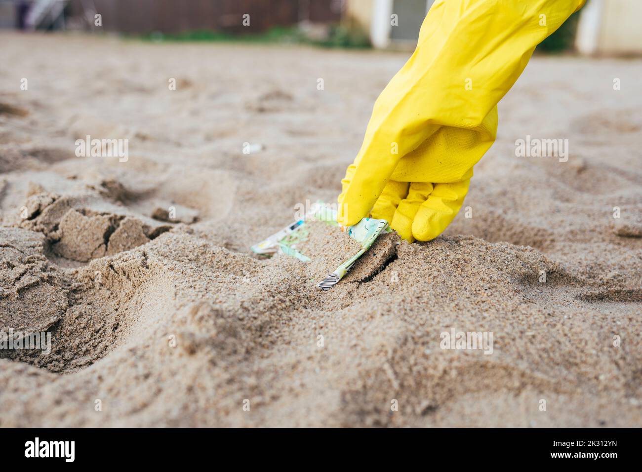 Hand of woman picking up waste from sand at beach Stock Photo - Alamy
