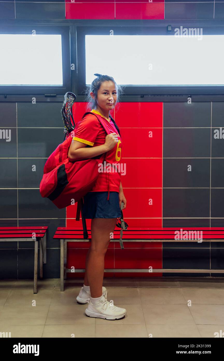 Young athlete with backpack standing in locker room Stock Photo - Alamy