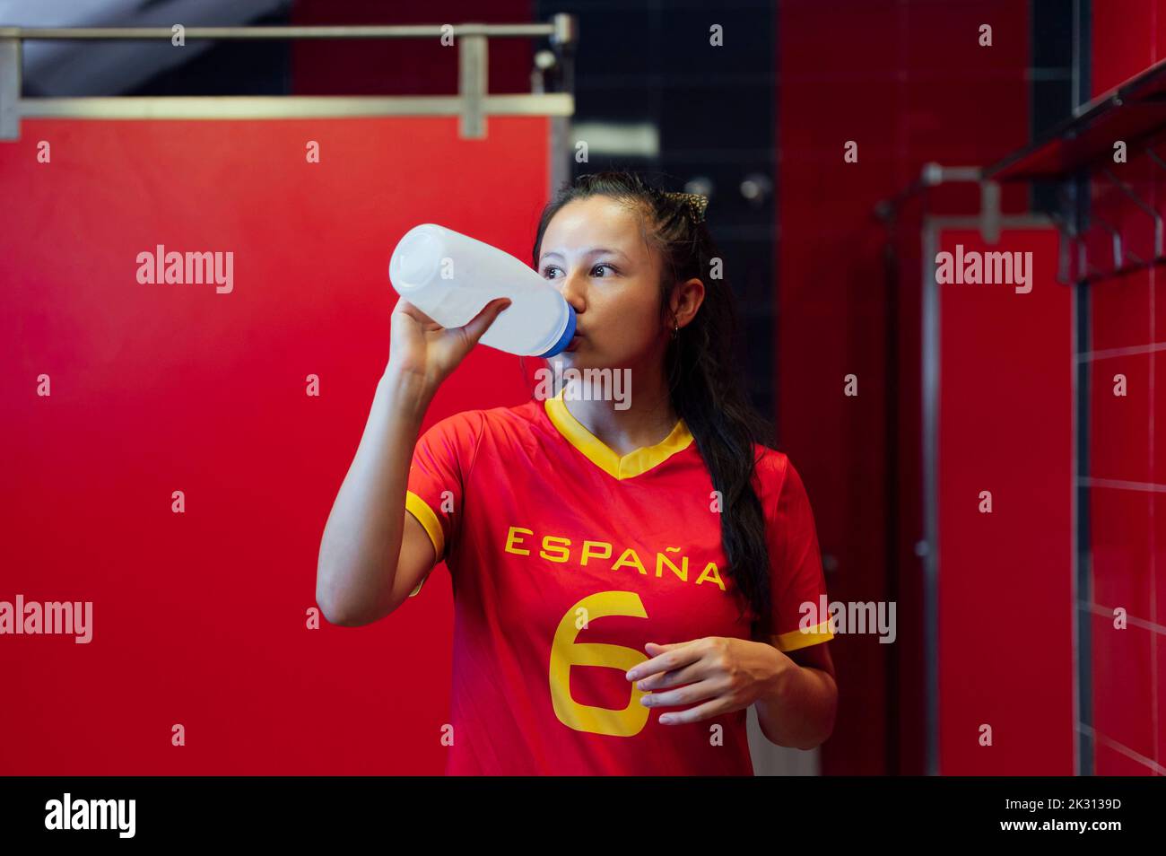 Young player drinking water in locker room Stock Photo - Alamy