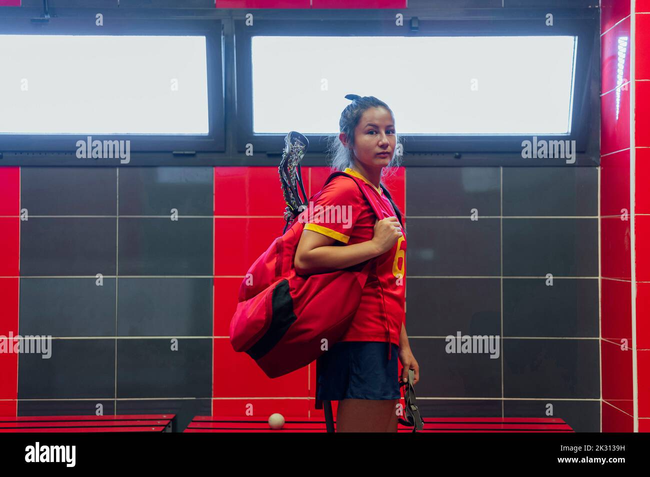 Lacrosse player standing with backpack in locker room Stock Photo - Alamy