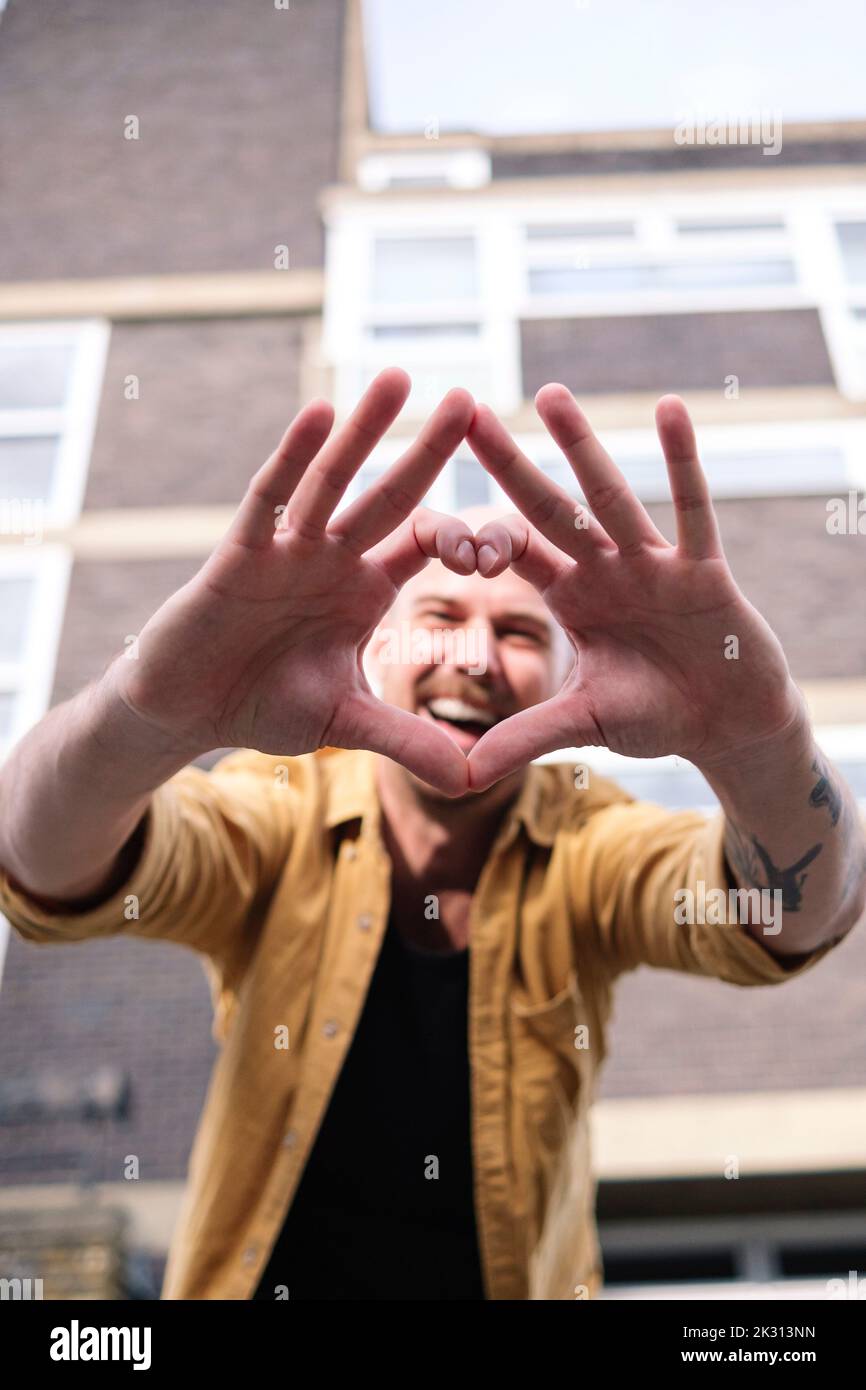 Happy man gesturing heart shape with hands Stock Photo - Alamy