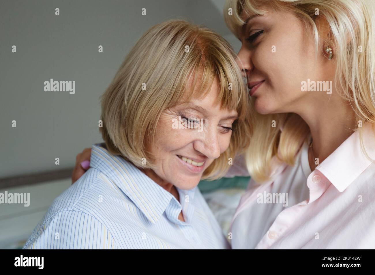 Happy daughter embracing and caring mother at home Stock Photo - Alamy