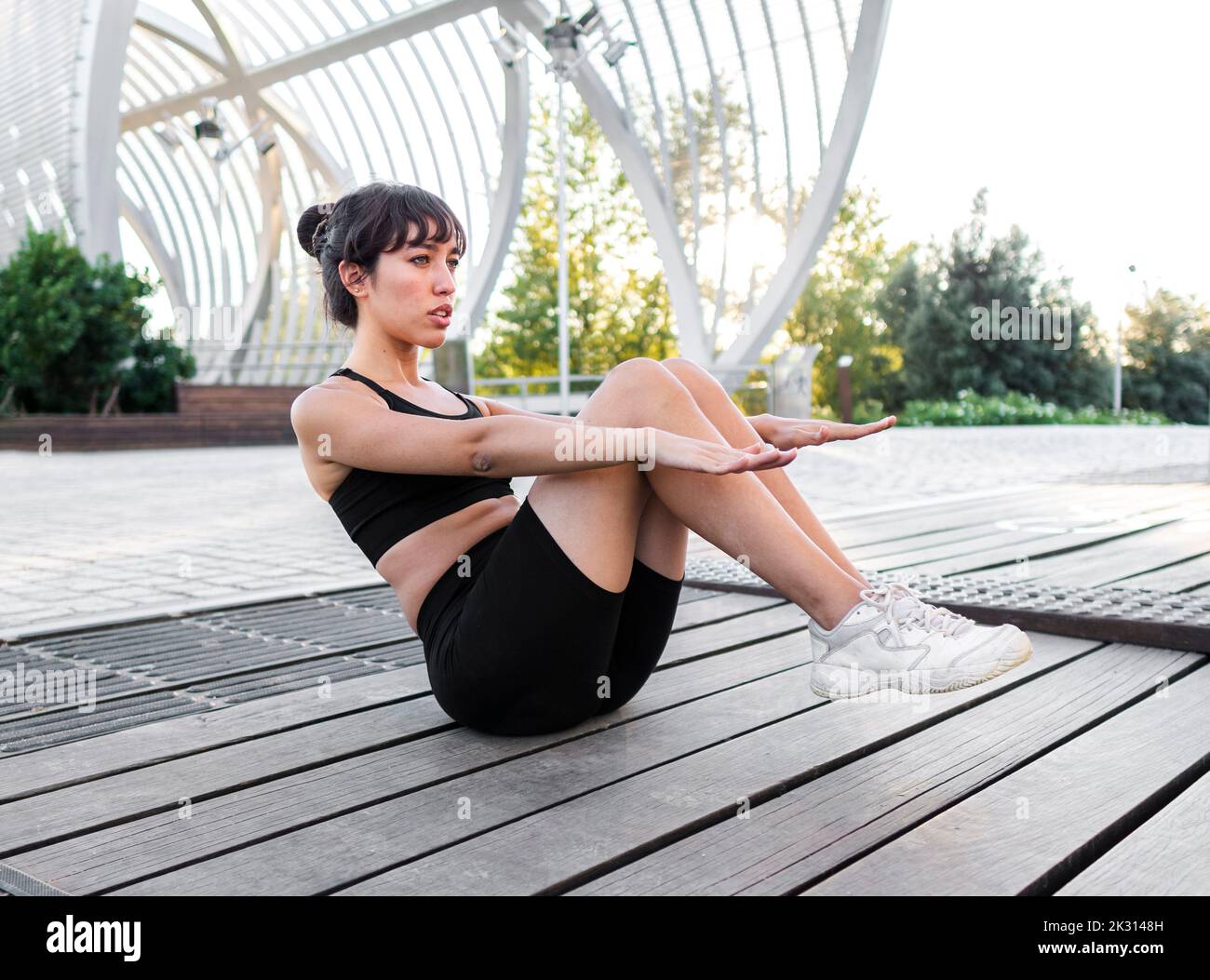 Young woman practicing abdominal muscle exercise at footpath Stock ...