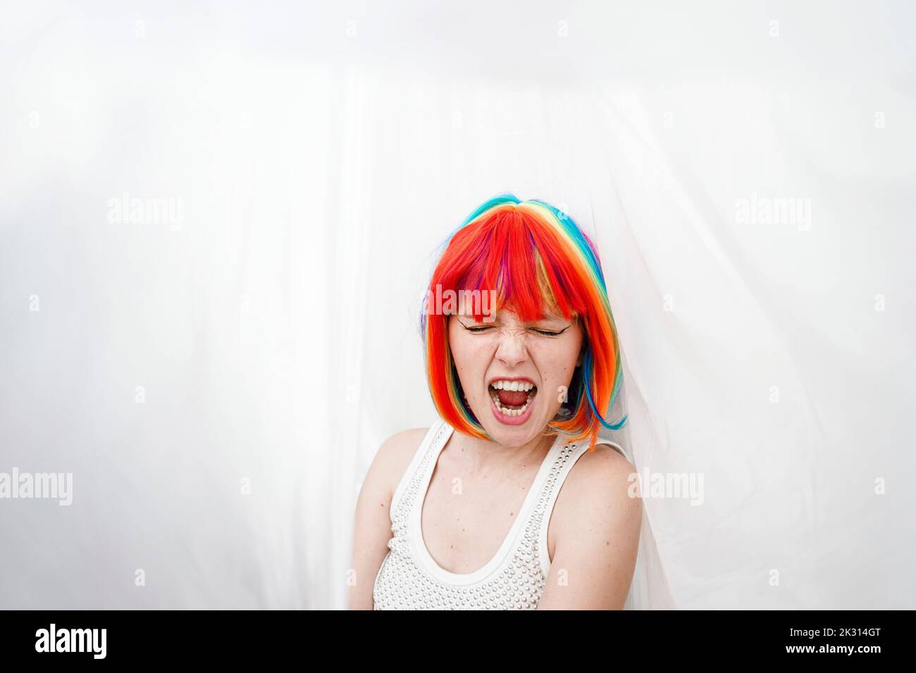 Woman with colorful dyed hair screaming by plastic backdrop Stock Photo ...