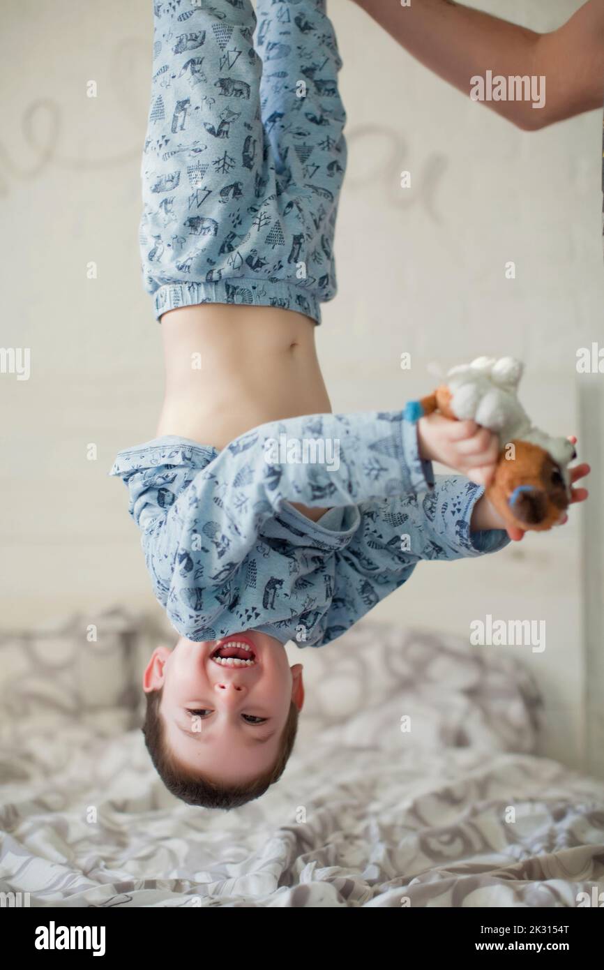 Hands of man holding son upside down at home Stock Photo - Alamy