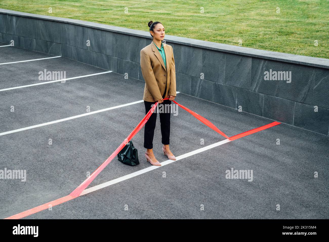 Businesswoman pulling red line at parking lot Stock Photo - Alamy