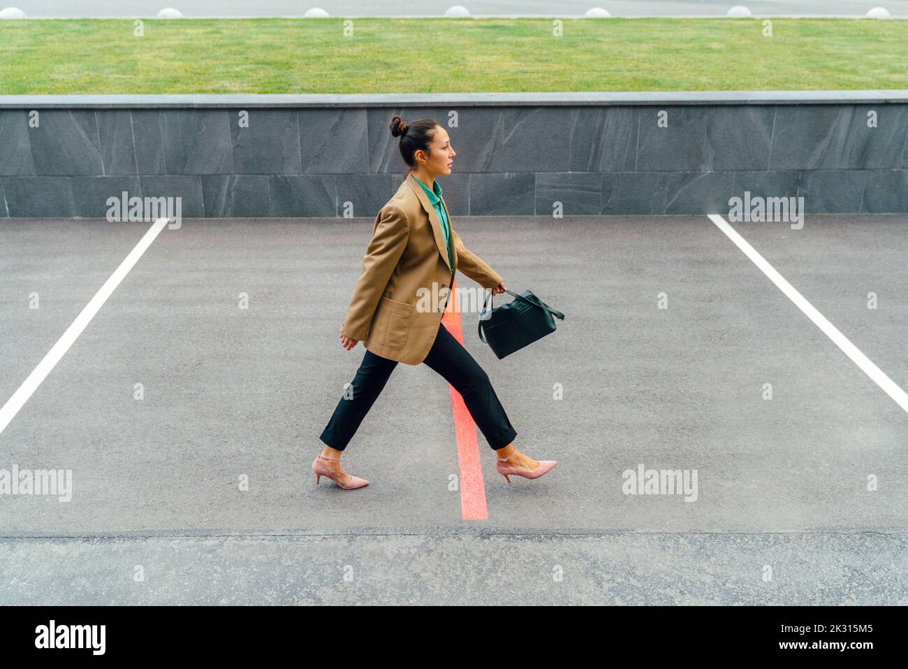 Businesswoman crossing red line walking at parking lot Stock Photo - Alamy