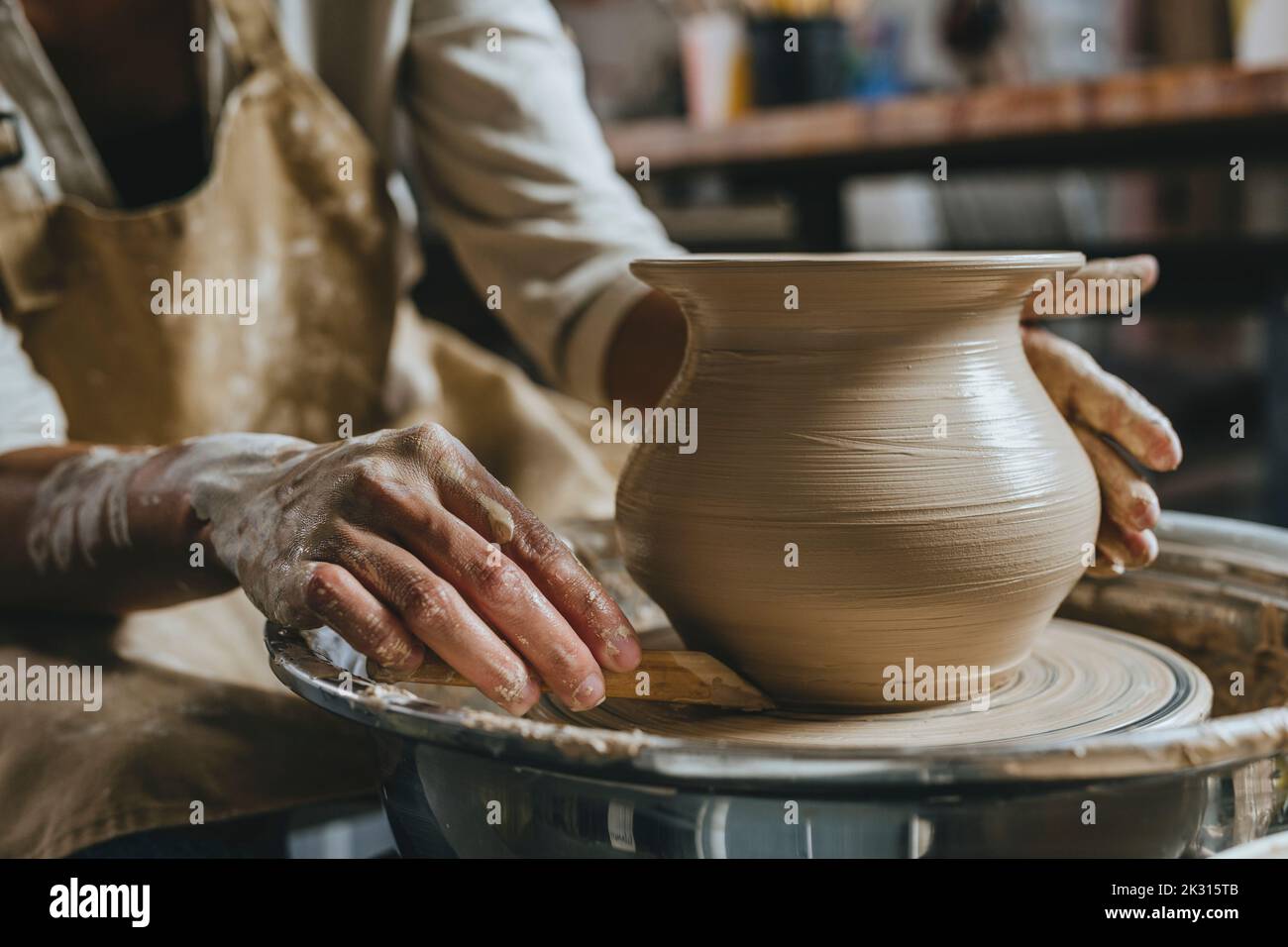 Hands of young potter molding pot shape on pottery wheel Stock Photo ...