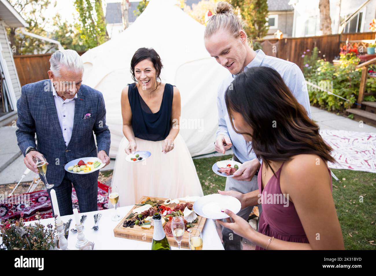 Mature newlyweds and guests enjoying appetizer at wedding reception ...