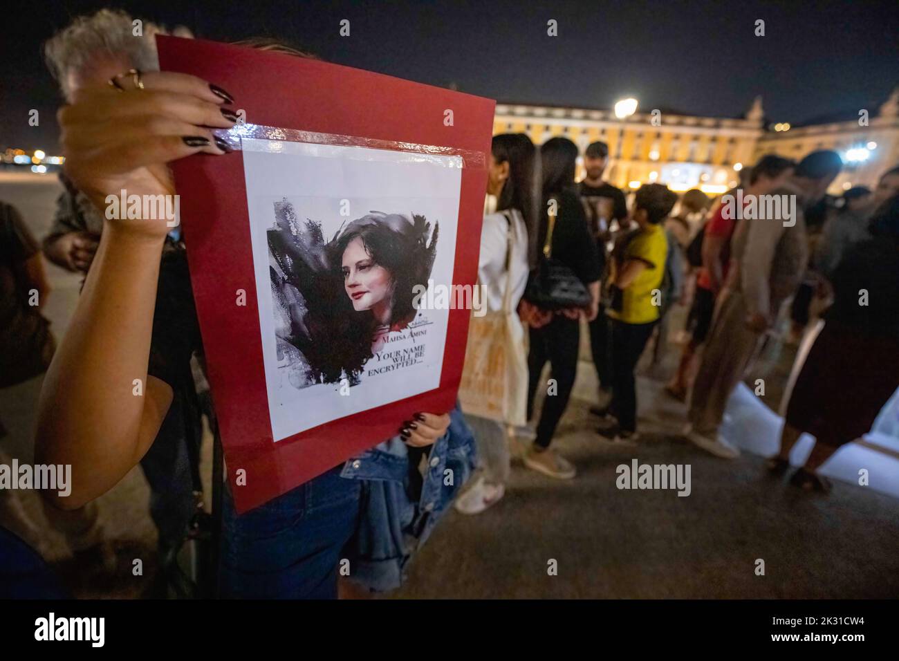 An activist is seen holding a picture of Mahsa Amin during a rally in ...