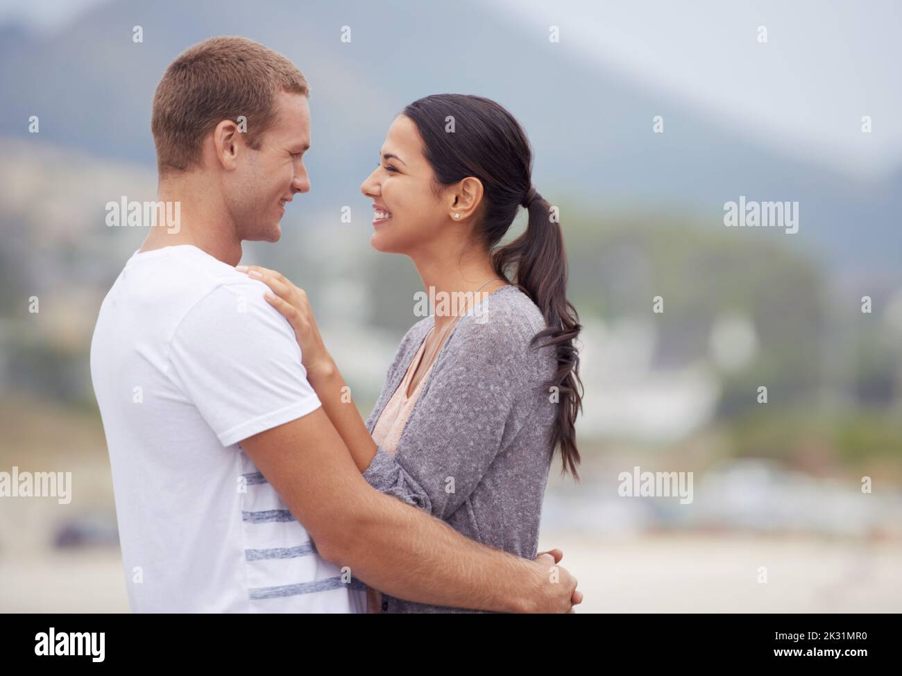 Sharing a loving gaze and a warm embrace. an affectionate young couple ...