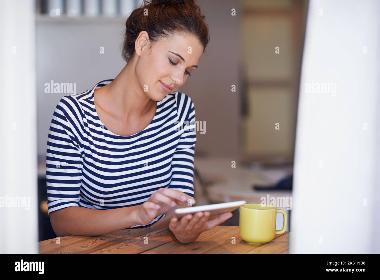 Her friends are just a tap away. a young woman working on her digital ...