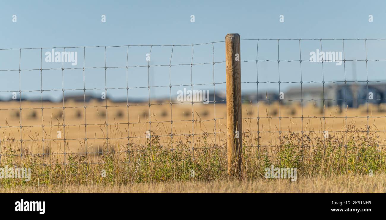 wire fence with farm fields behind it Stock Photo - Alamy