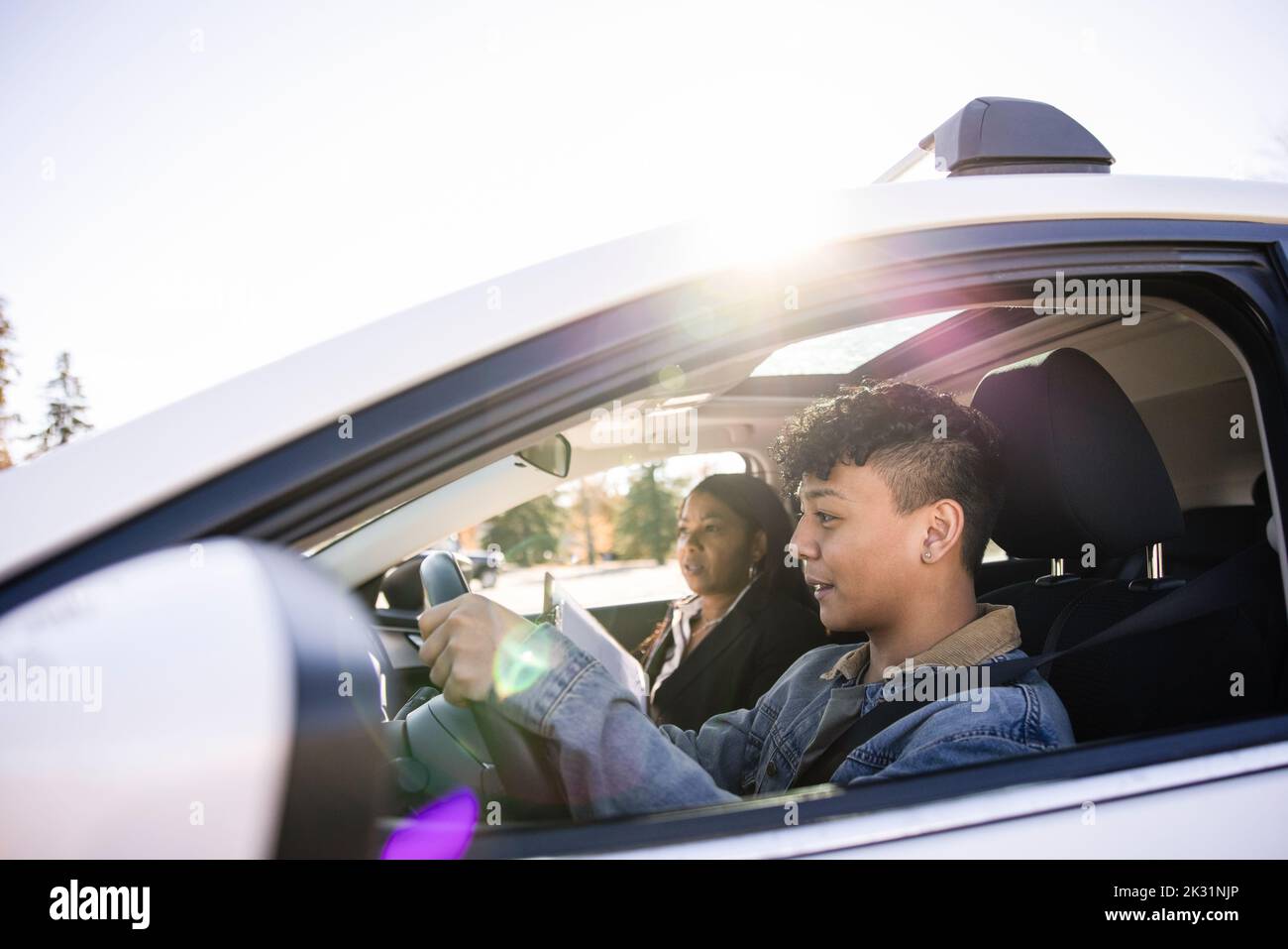 Driving student in sunny car with instructor Stock Photo - Alamy
