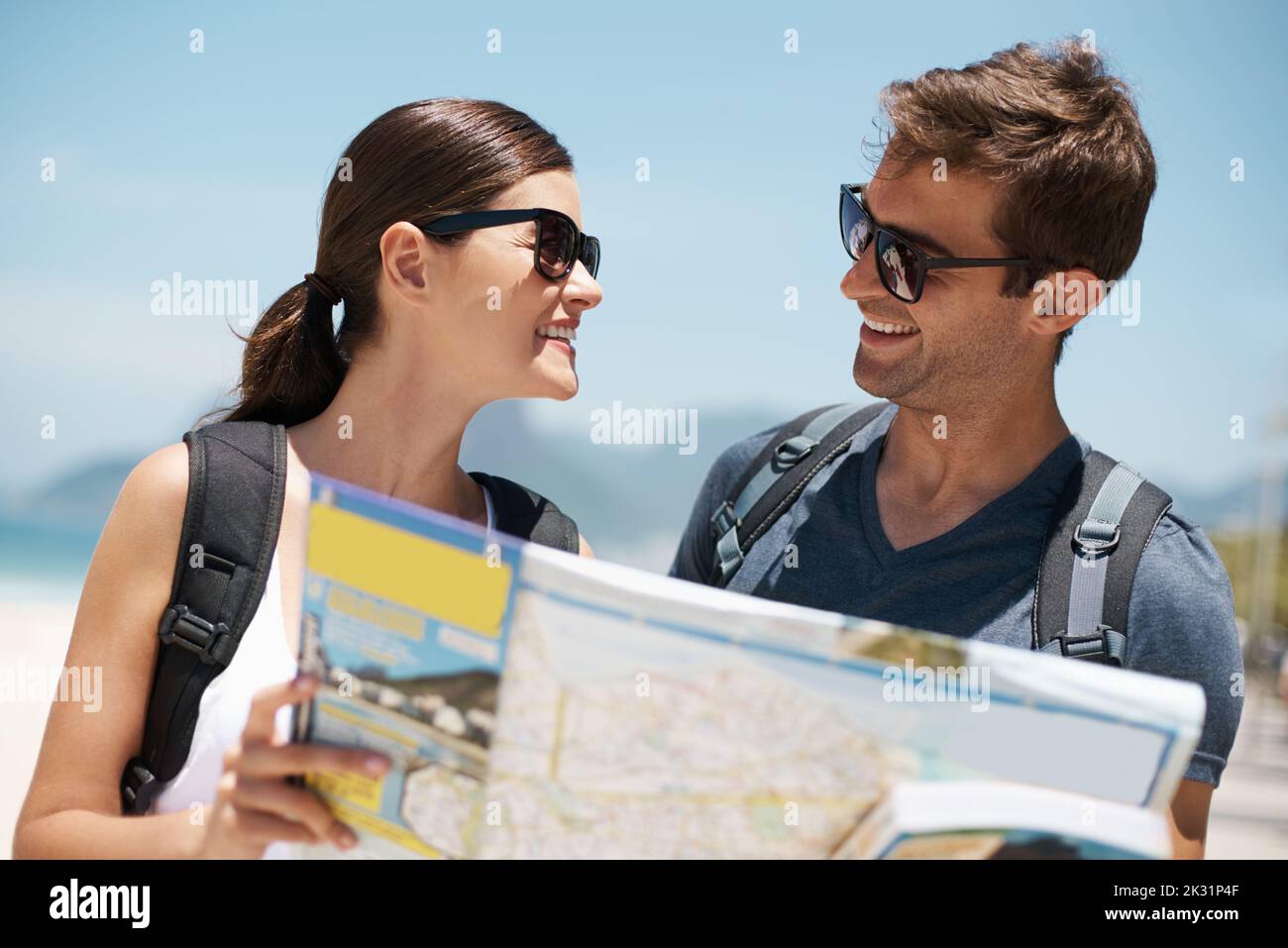 Traveling with someone I love. a young couple looking at a map while ...