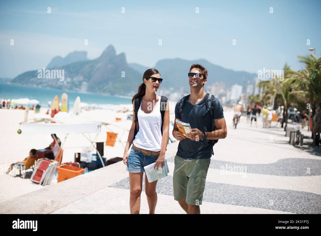 Strolling along through paradise. a young couple walking beside the ...