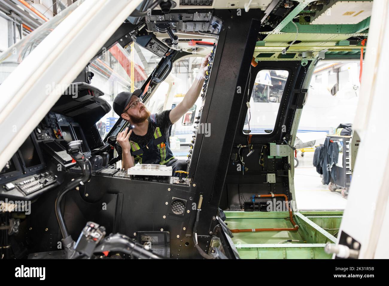 Technician working in helicopter cockpit Stock Photo - Alamy