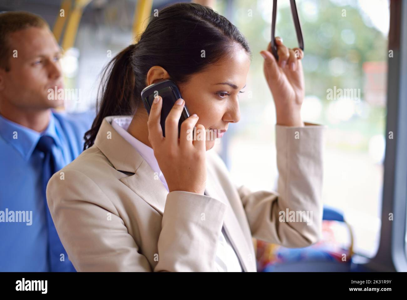 Staying connected to her business on the bus. Two young colleagues ...