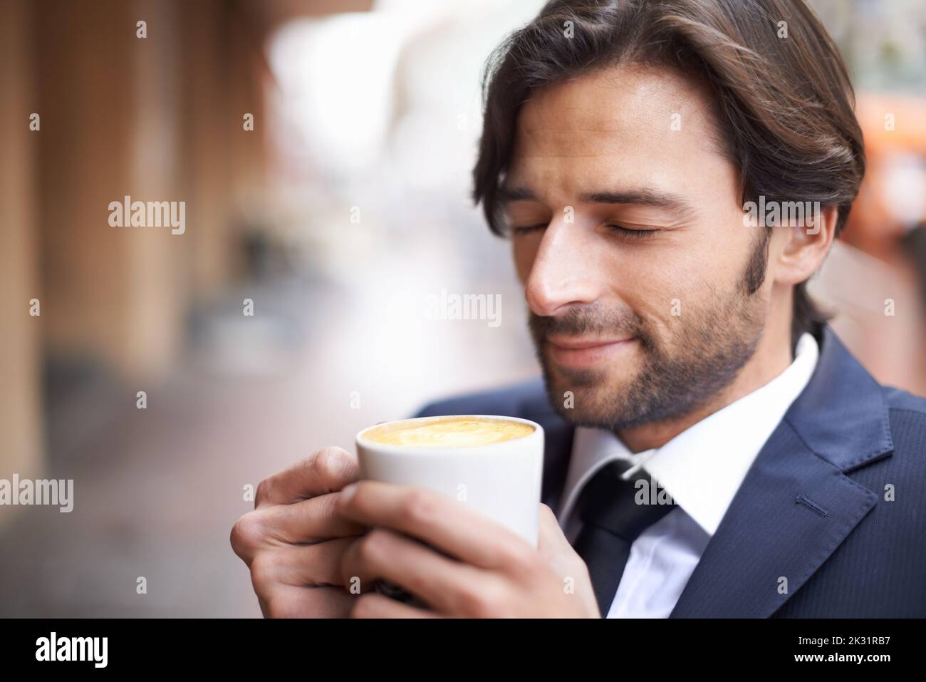 Nothing like the first sip of the day. A handsome businessman enjoying ...