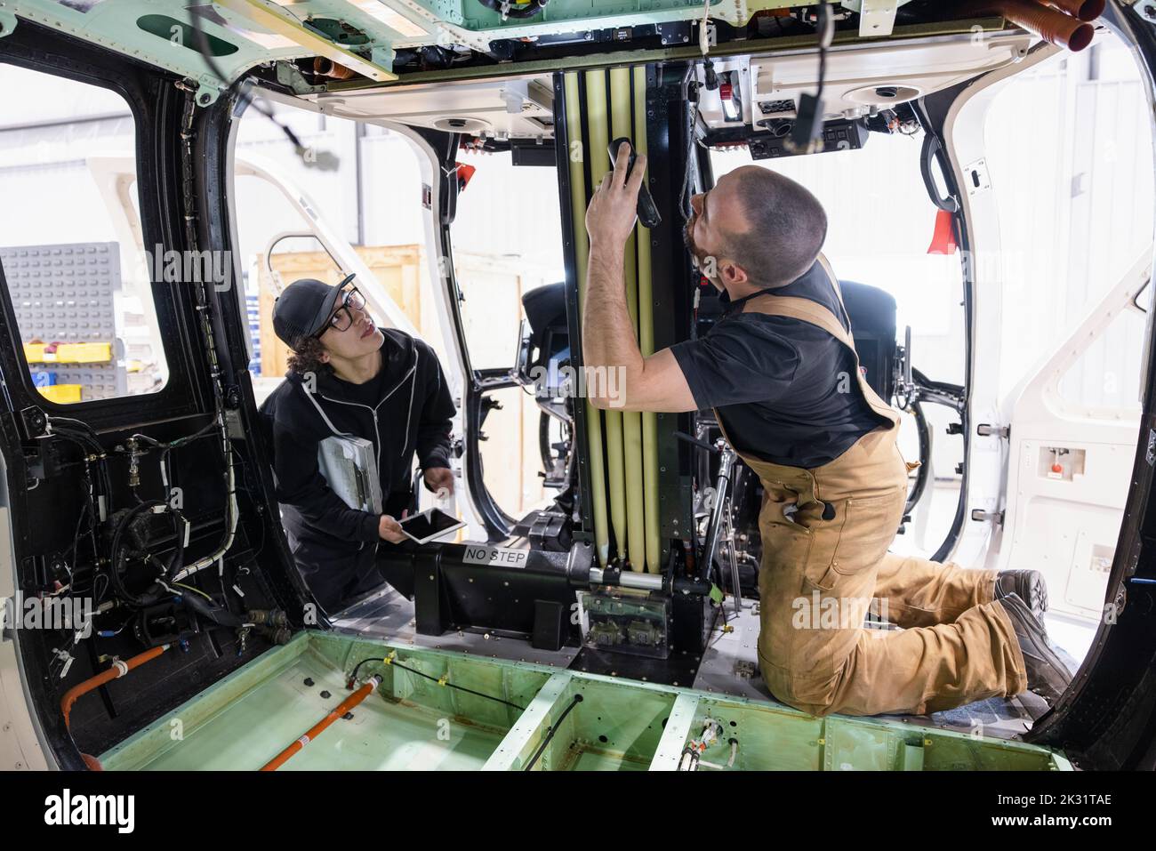 Technicians working in helicopter cockpit Stock Photo - Alamy