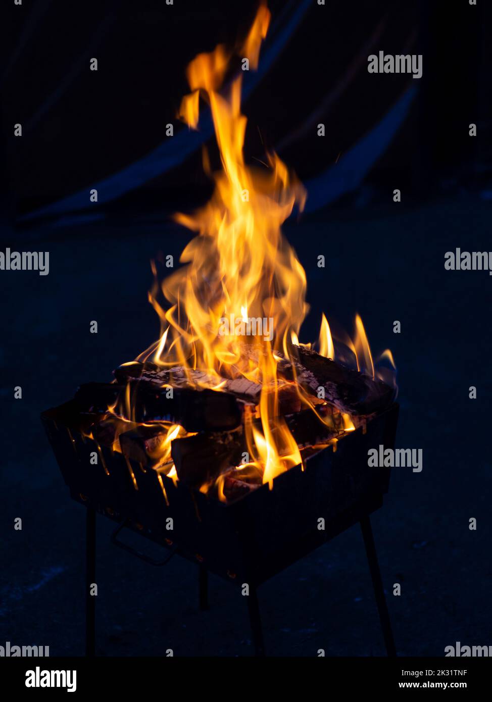 Evening open fire flame outdoors. Red flames of campfire on dark ground ...