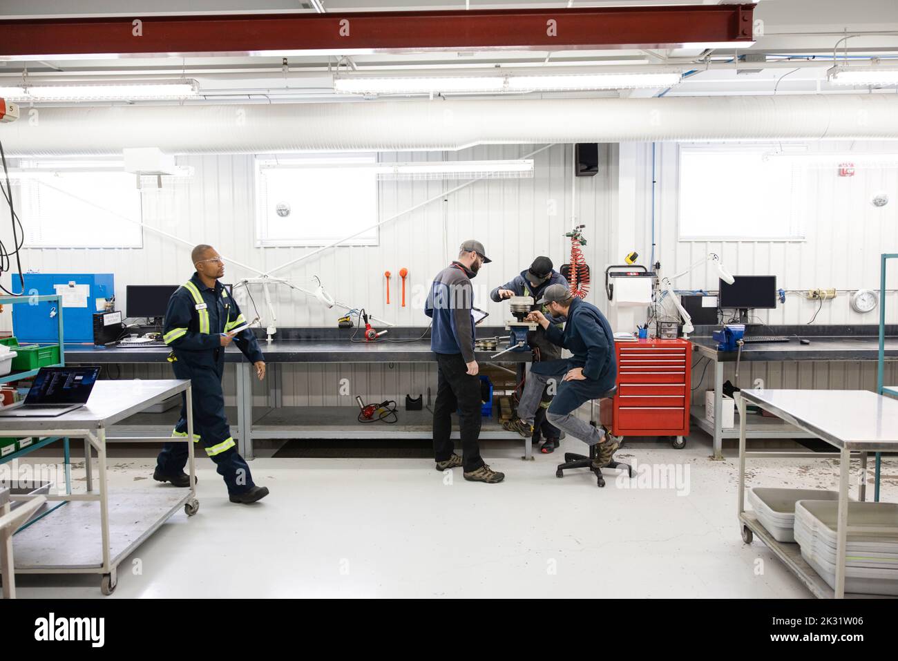 Engineer showing colleagues how to repair helicopter part Stock Photo ...