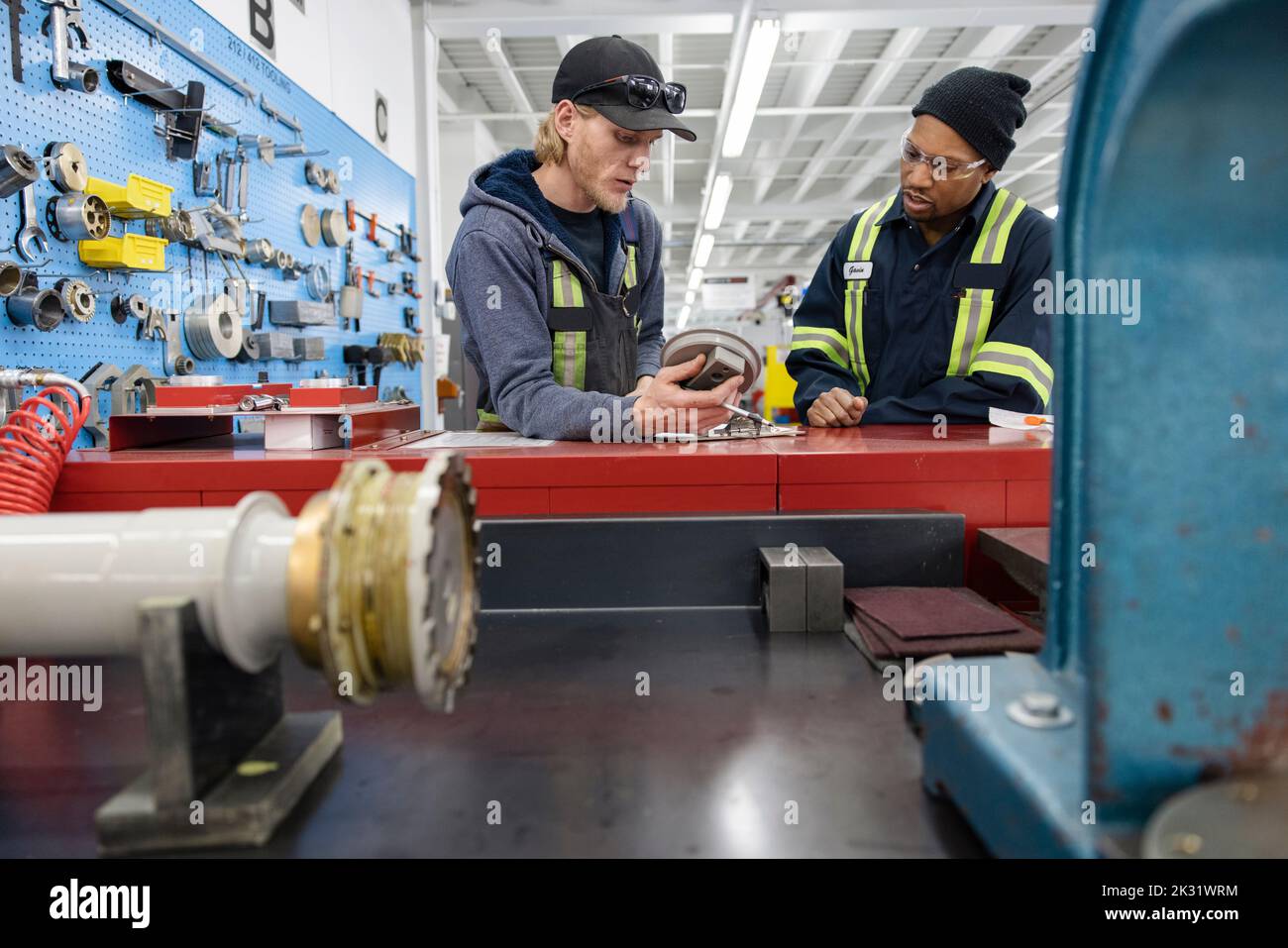 Technicians checking components on list Stock Photo - Alamy