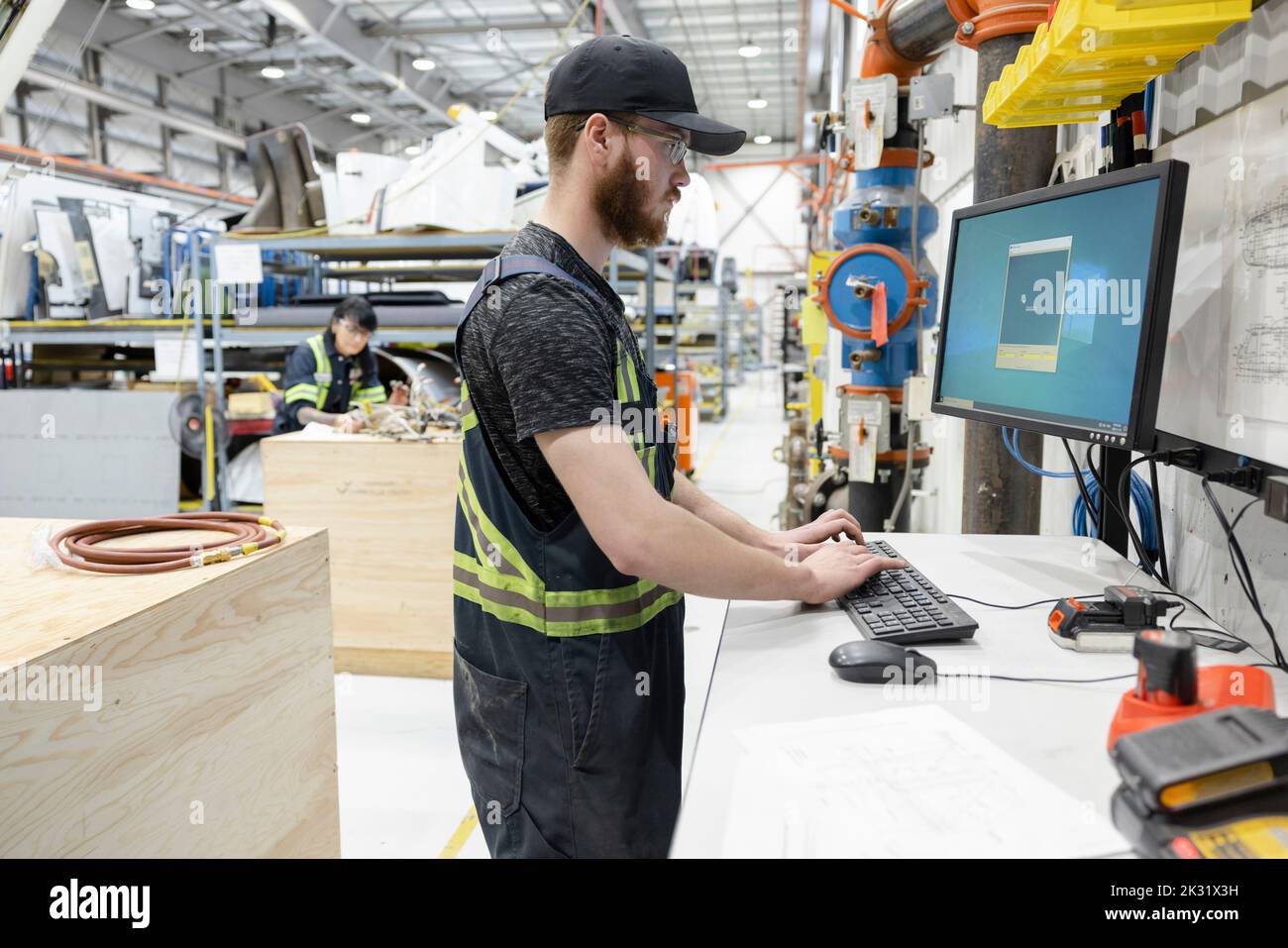 Technician using computer in helicopter hangar Stock Photo - Alamy