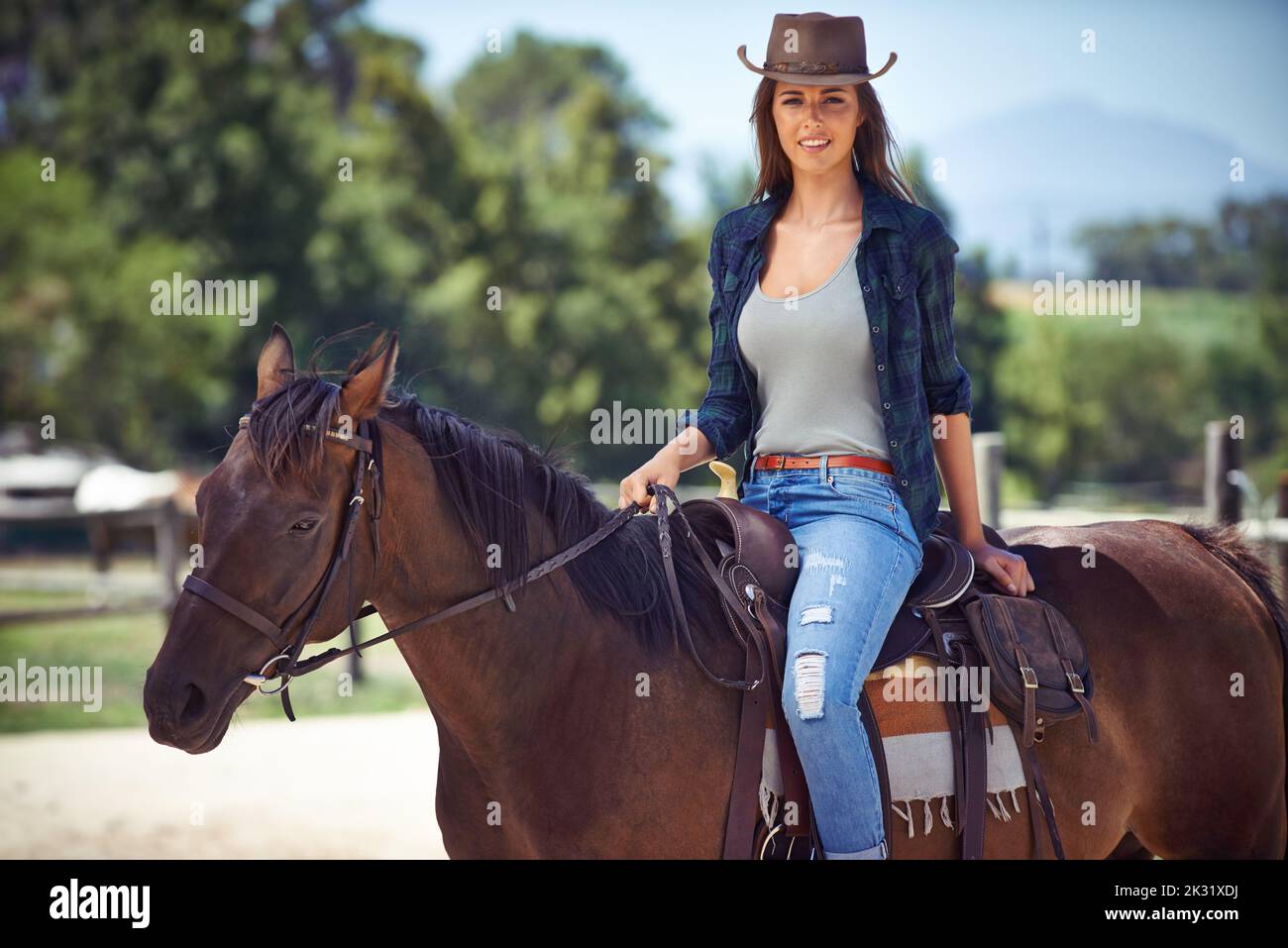 Loving the outdoors. Portrait of a gorgeous cowgirl with her horse at a ranch Stock Photo - Alamy