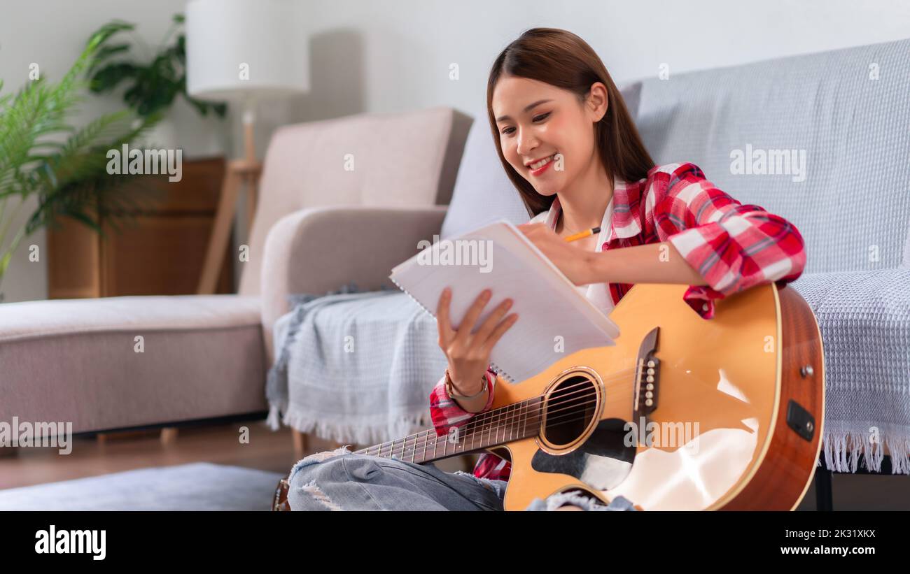 Guitar and singer concept, Young woman is composing song while playing ...