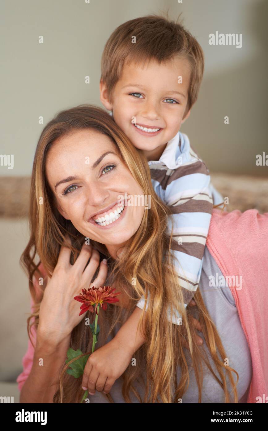 Mommys little champ. a mother holding a flower her son gave hr for ...