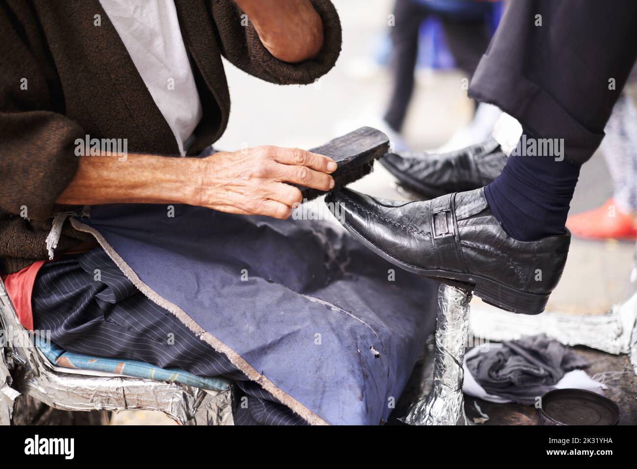 Keeping the businessmens shoes shiney. a shoe shiner shining a ...
