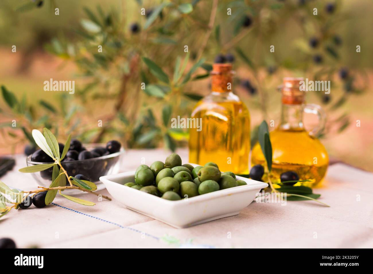 still life of olives and oil on a table against a background of olive ...