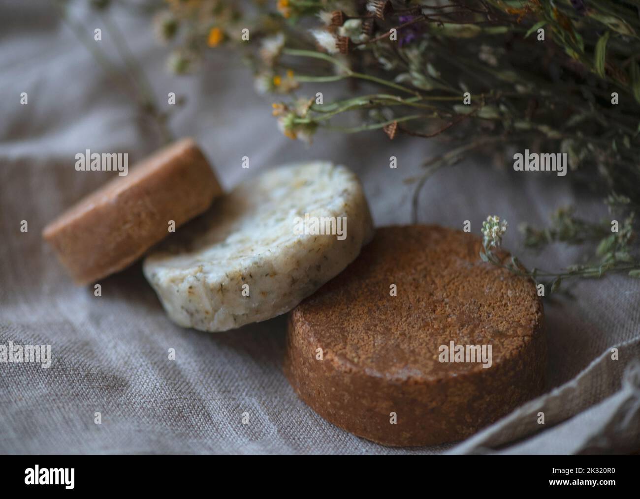 Stack of assorted natural soap bars on linen textile cloth. Pastel ...