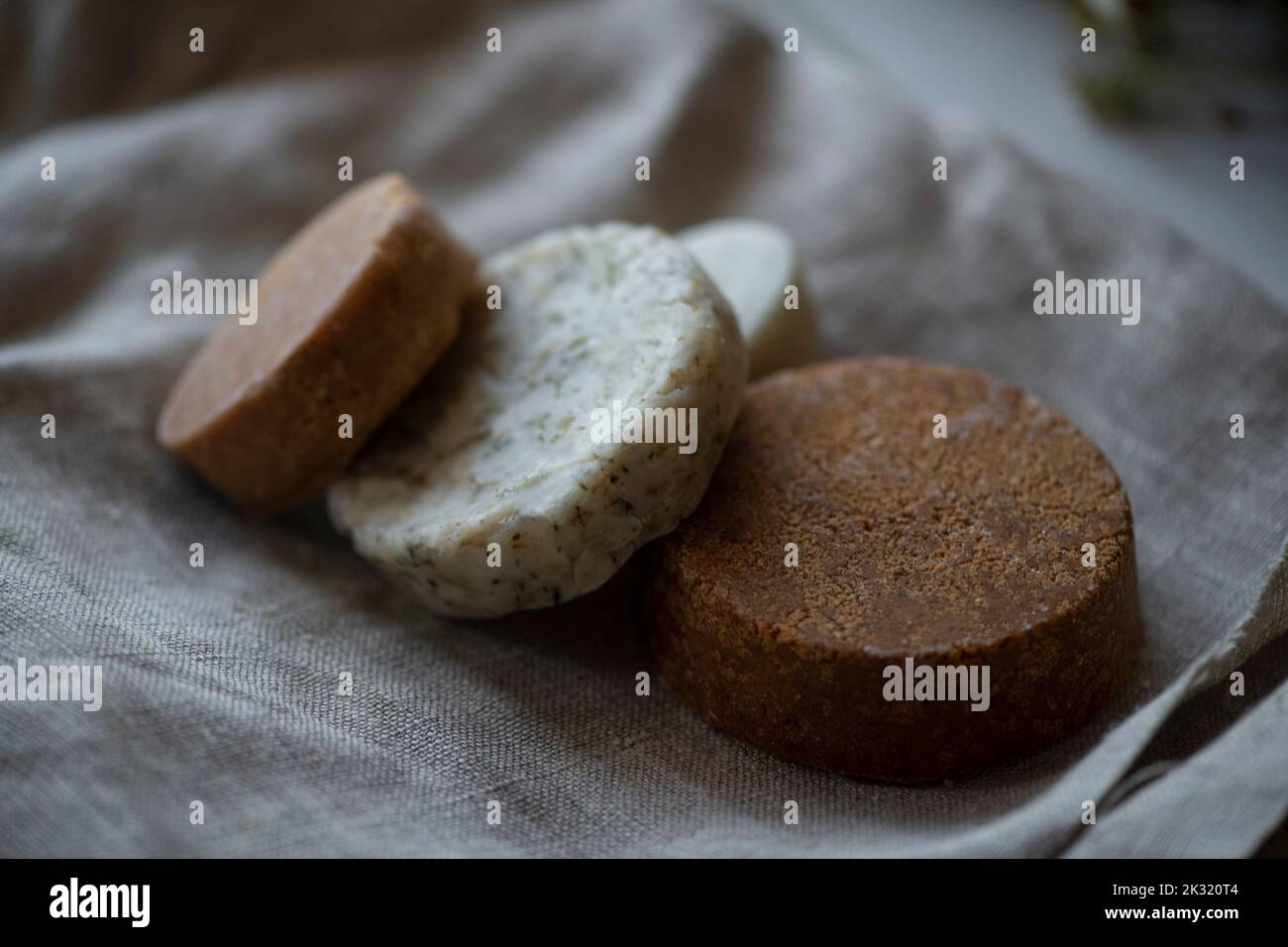 Stack of assorted natural soap bars on linen textile cloth. Pastel ...