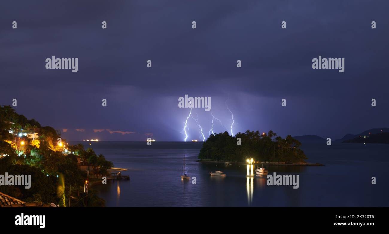 Stormy night over the island. a dramatic thunderstorm over sea and land ...