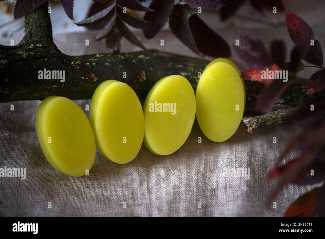 Stack of assorted natural soap bars on linen textile cloth. Pastel ...
