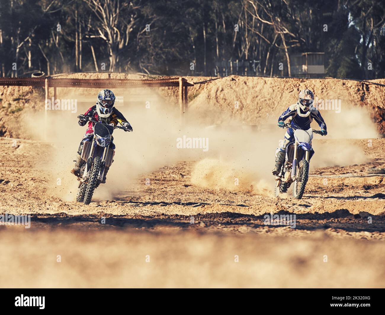 Time to rip up this track. two motocross racers speeding along the ...