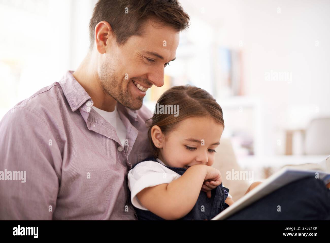 Reading her favourite story. a young father reading a book with his ...