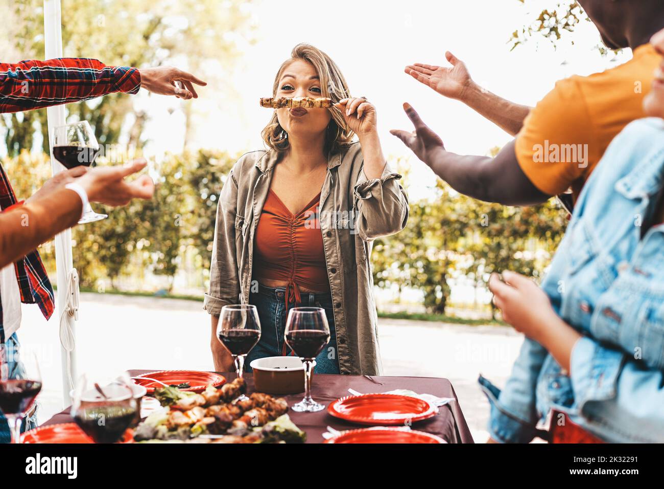 Friends having fun party pointing a curvy young woman making faces ...