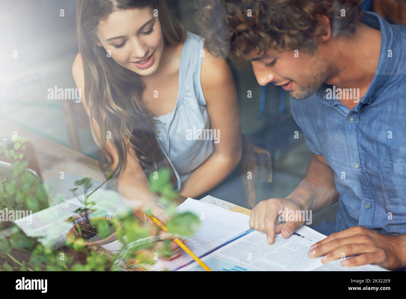Working through the chapter together. a young couple studying together ...