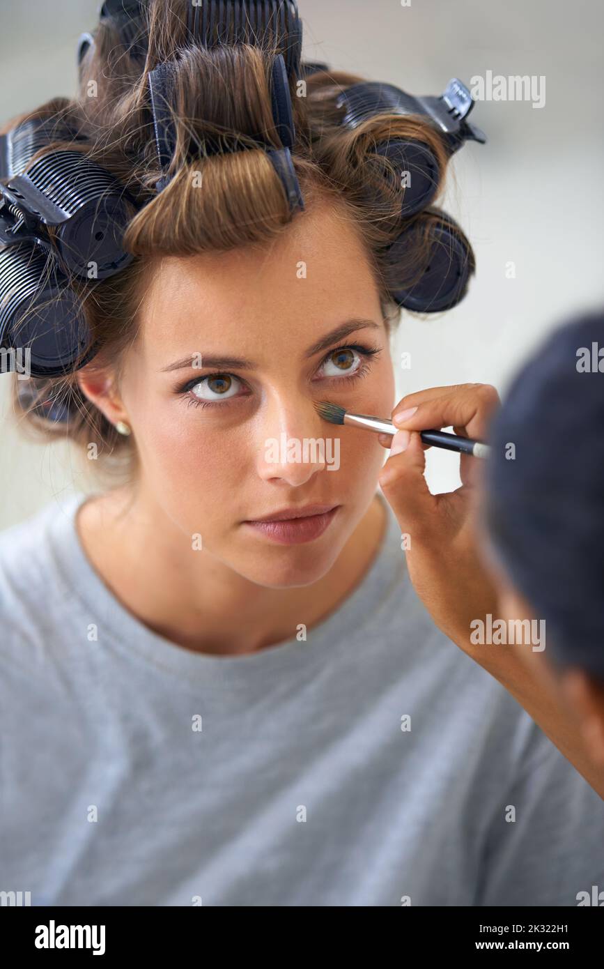 Putting on the final touches. A beautiful young woman spending the day ...