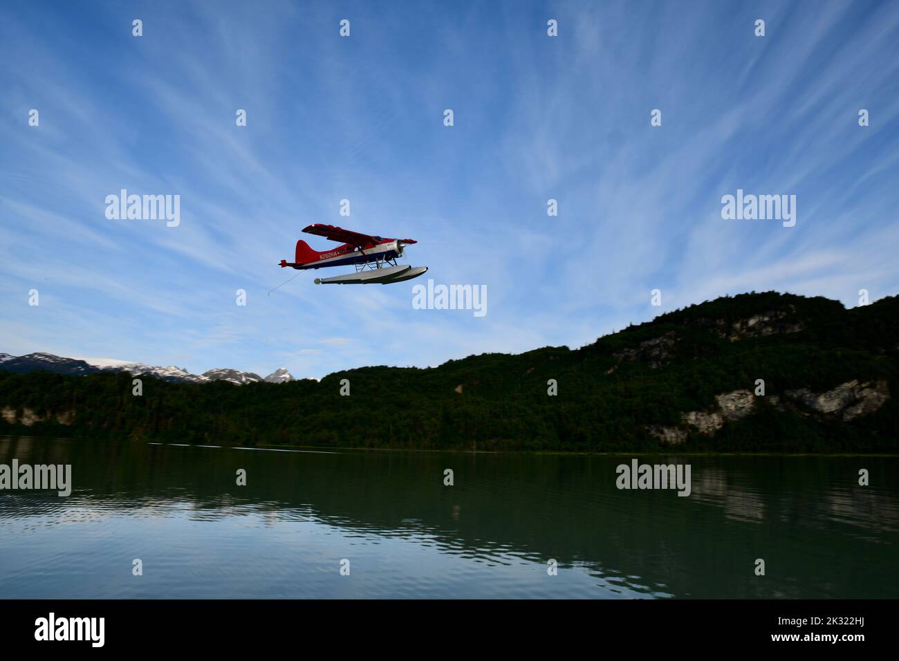 A red aircraft flying over the Big River Lake in Alaska Stock Photo - Alamy