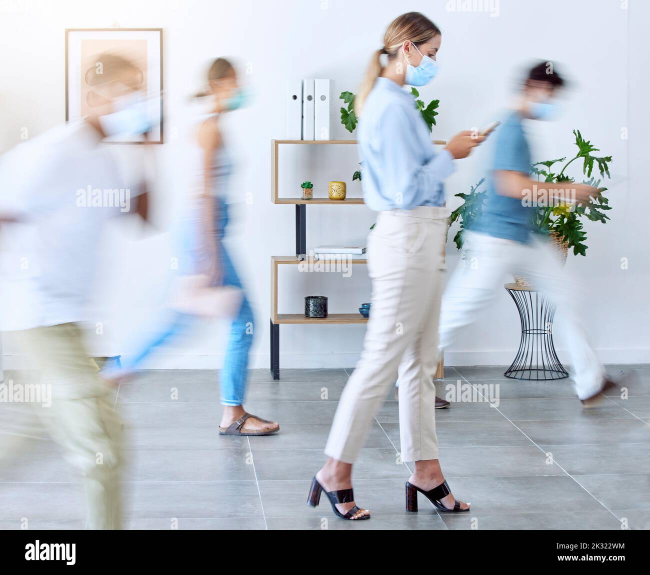 Covid, busy office and woman typing phone walking in modern office with ...