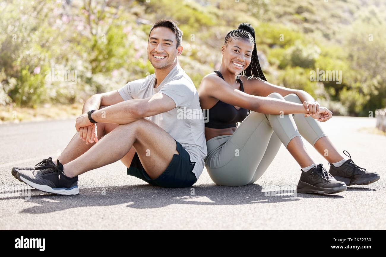 Portrait of couple resting in the street after workout, running and ...