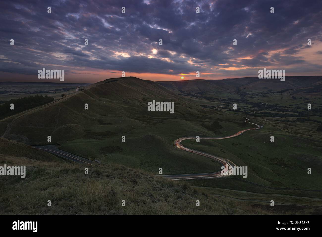 View towards Lords Seat from Mam Tor with car light trails at Sunset ...