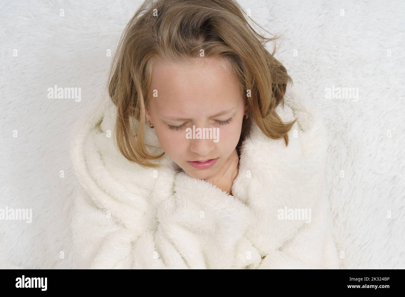 Sick teenage girl holds hand to sore throat. Colds, tonsillitis ...